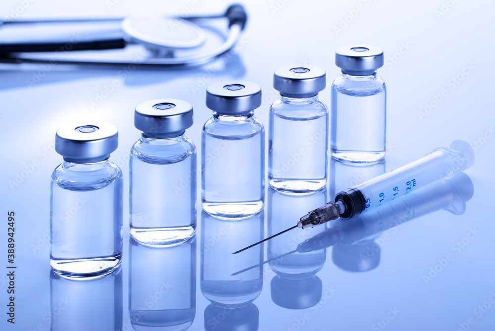 Vials with liquid drug as vaccine dose flu shot along with stethoscope ...