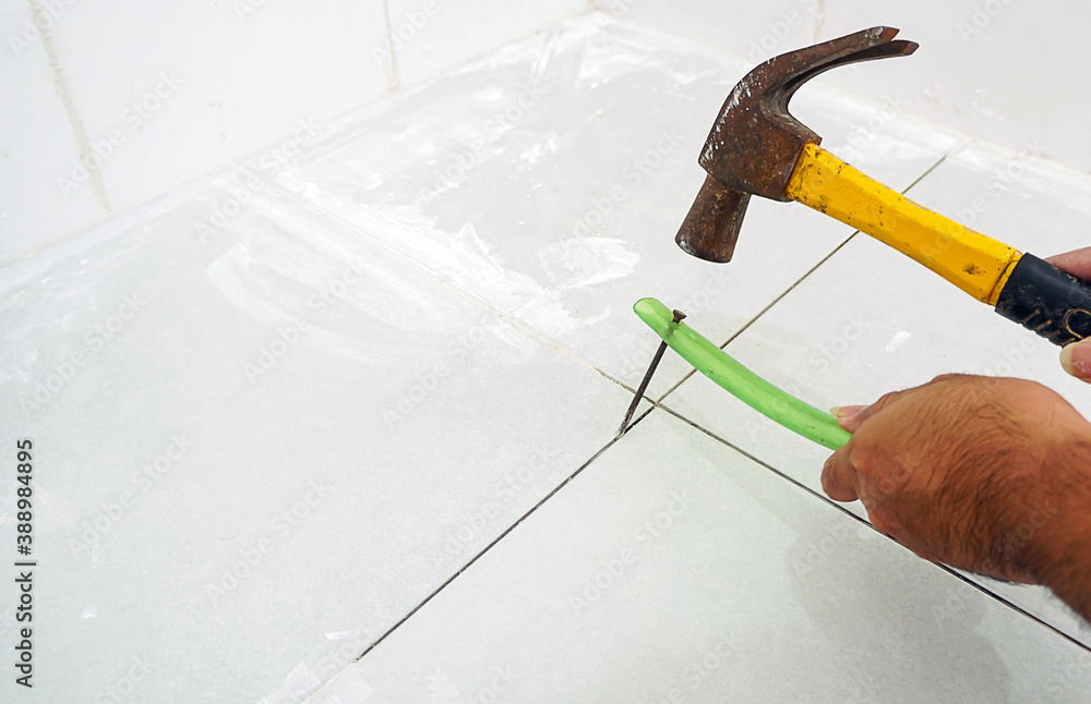 The man used nails with a hammer to peel the old grout. Replace the old ...