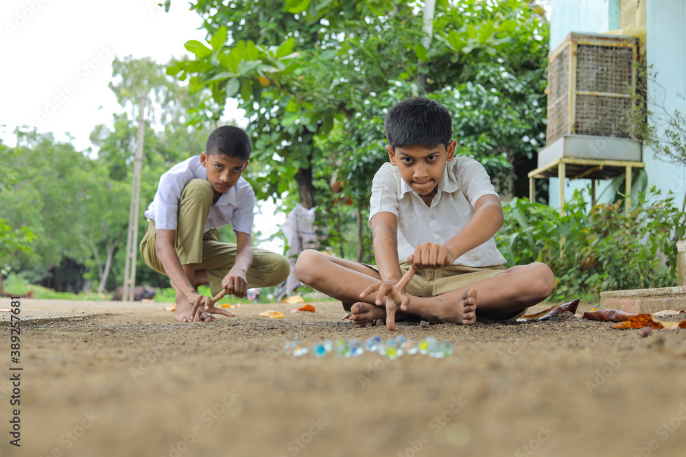 Indian child playing with glass marbles which is an old Indian village ...