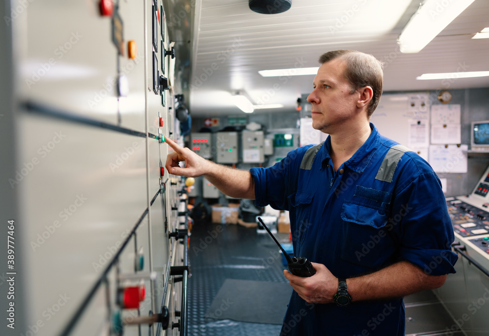 Marine engineer officer controlling vessel engines and propulsion in ...