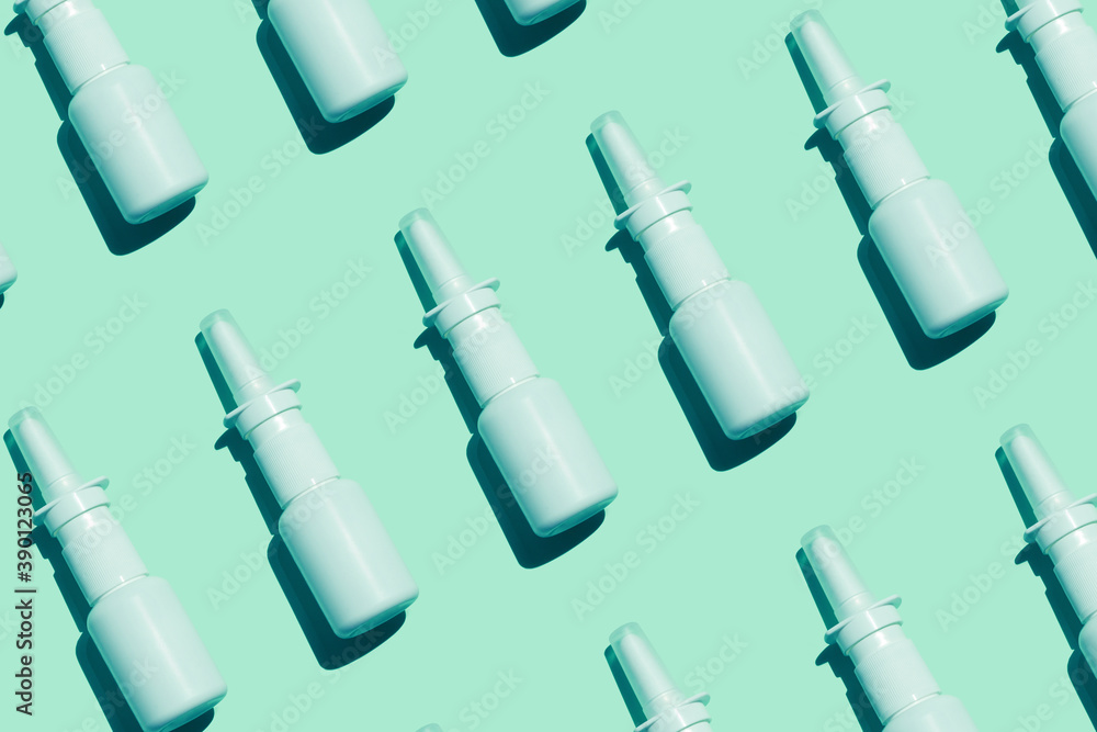 White medical nasal spray bottle on aqua mint background pattern flat ...