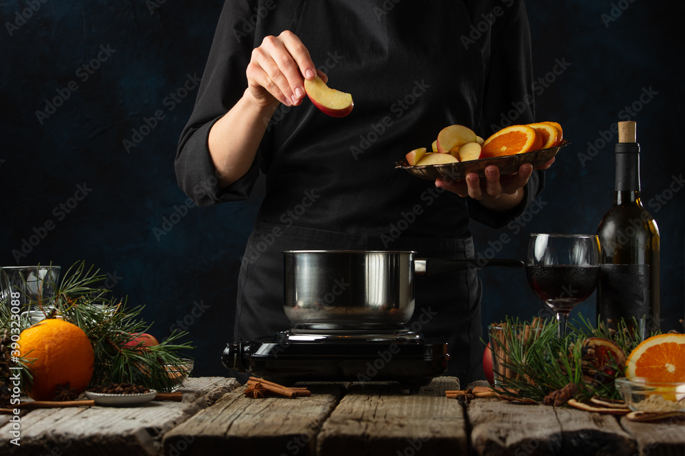 Photo Stock Chef pours chopped orange and apple into pot with wine fore ...