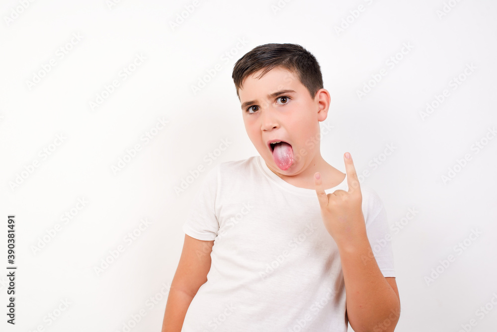 Portrait of a crazy Caucasian young boy standing against white ...