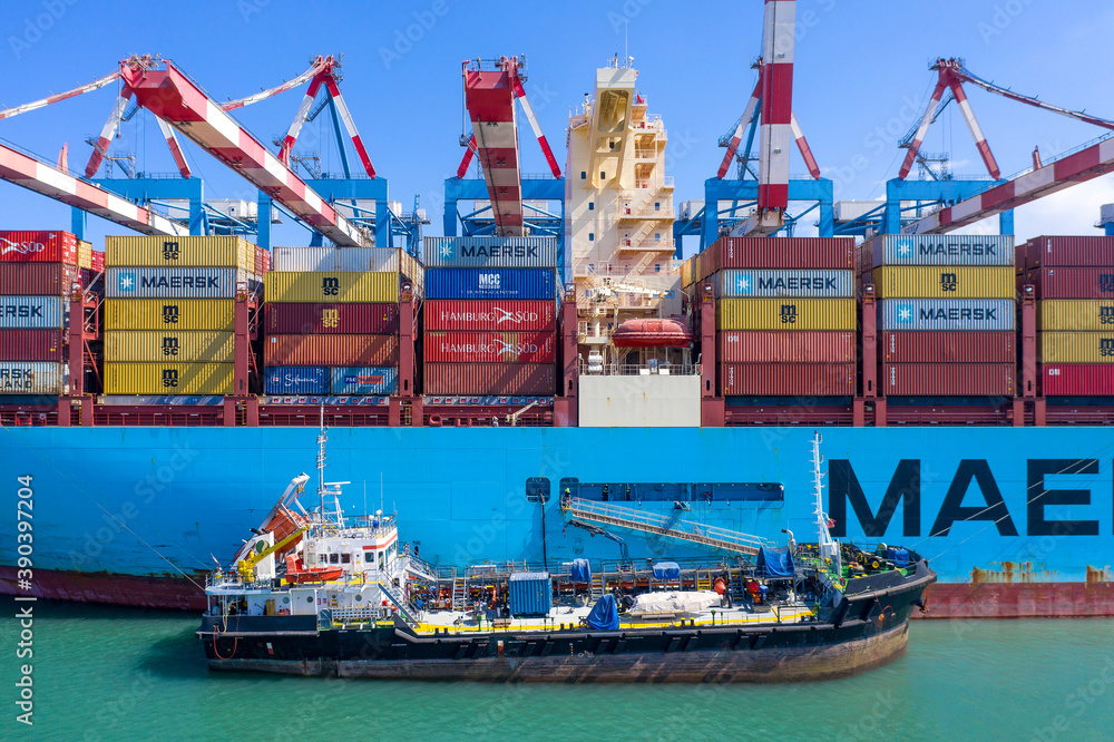 Bunkering operation at port, Small fuel tanker loading a Maersk mega ...