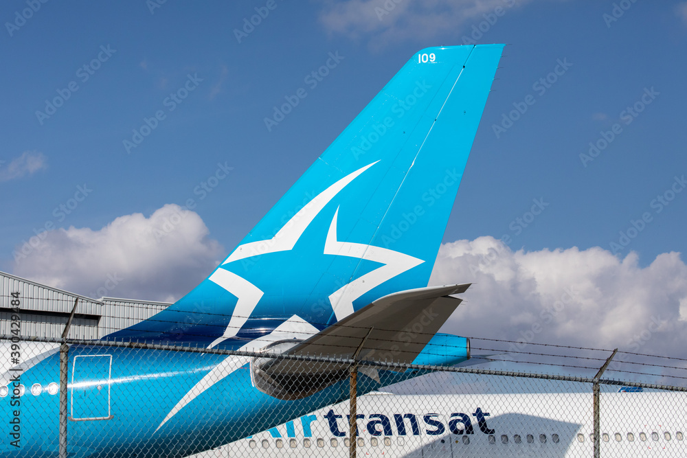 The tail of an Air Transat Airbus A320 jet airplane parked at a hangar ...