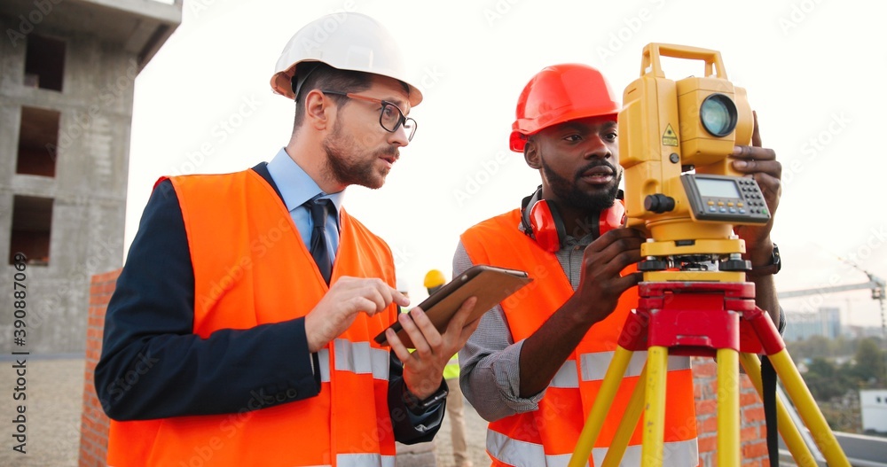 Caucasian man boss in tie with tablet device and in casque. African ...
