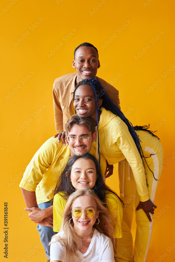studio shoot of encouraged models of diverse races isolated on yellow ...