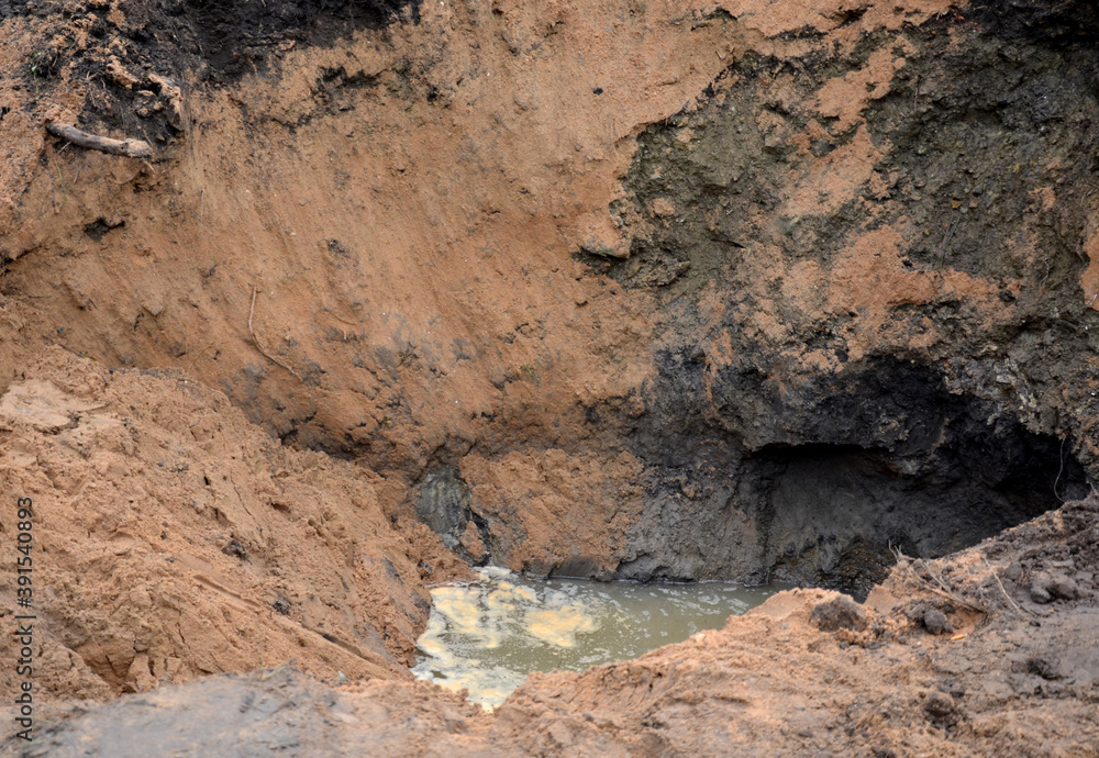 deep excavation flooded by water when the pipeline failed. mining of sand, gold by the stream ...