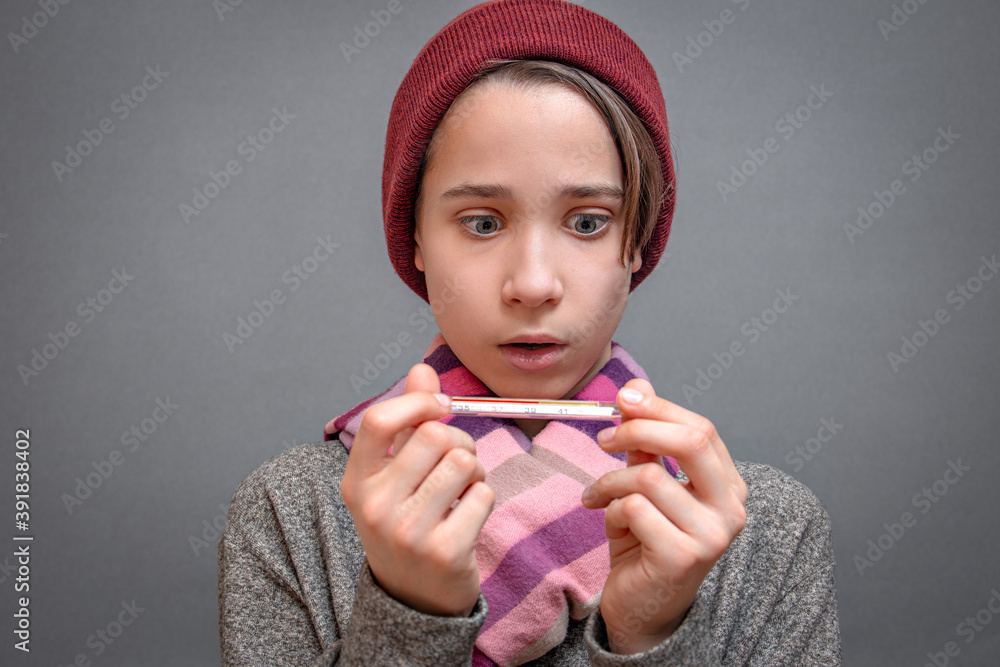 boy in a scarf and a hat holding a retro thermometer, high body ...