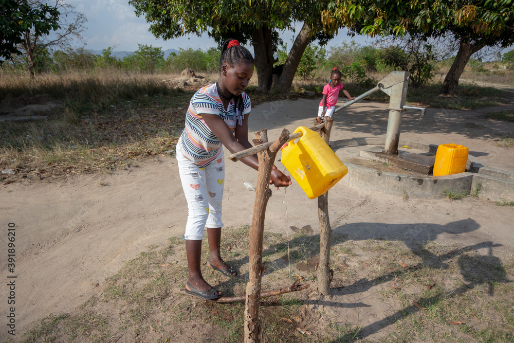 Foto de Stock Young girl washing hands on gallon of water recycled and ...