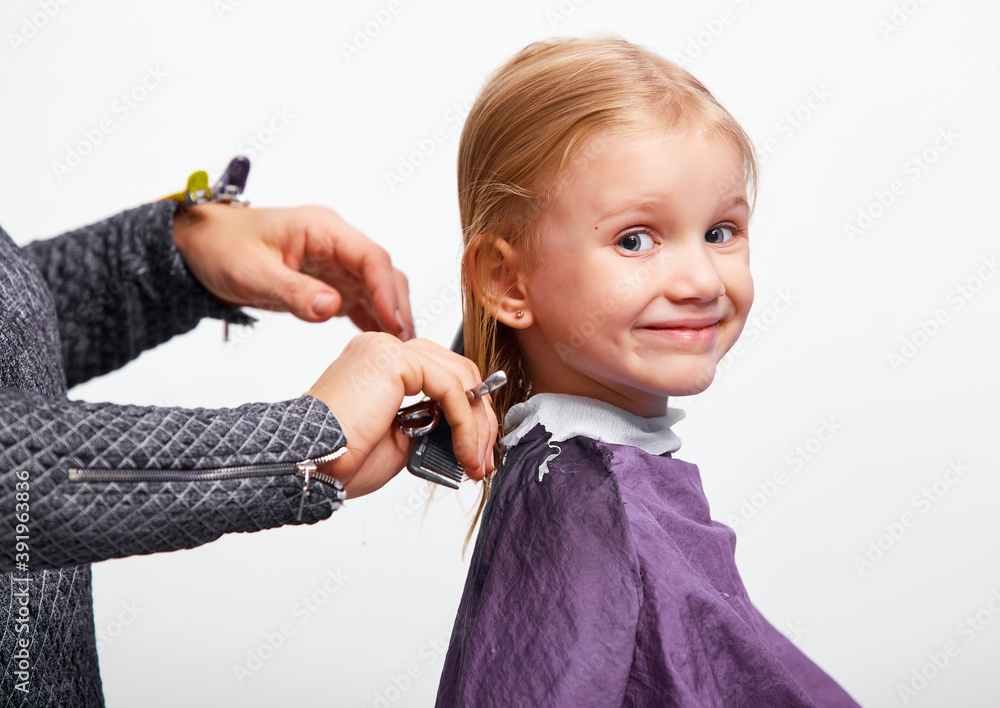 Foto Hair cutting process. Beautiful little girl at the barber shop ...