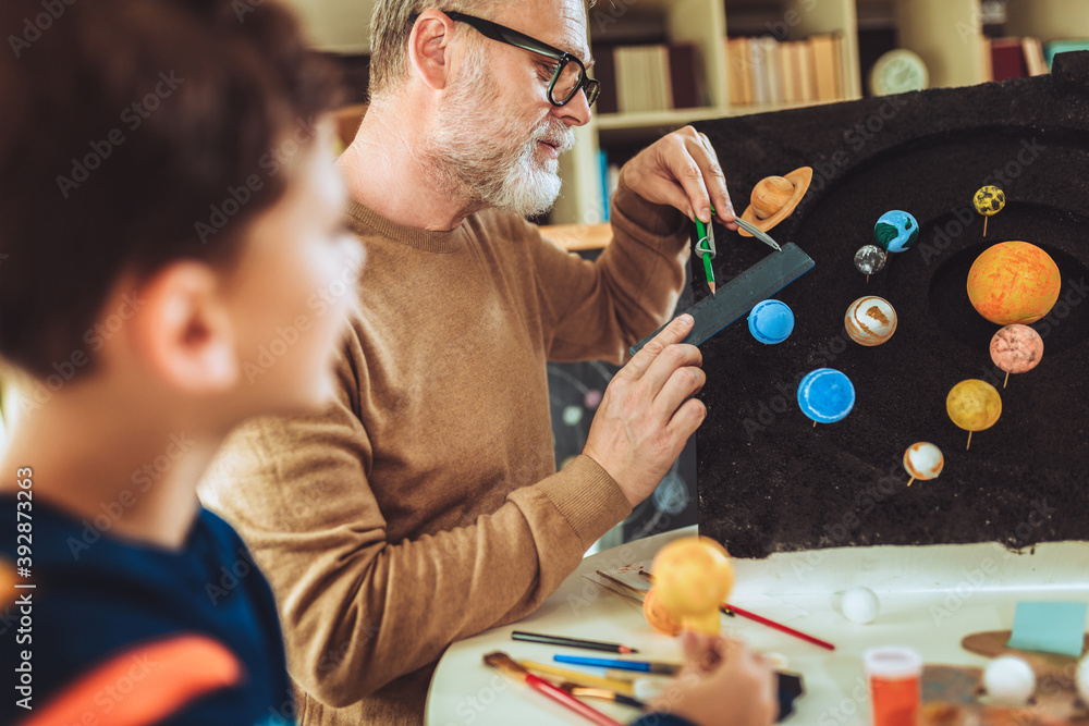 Happy school boy and his father making a solar system for a school ...