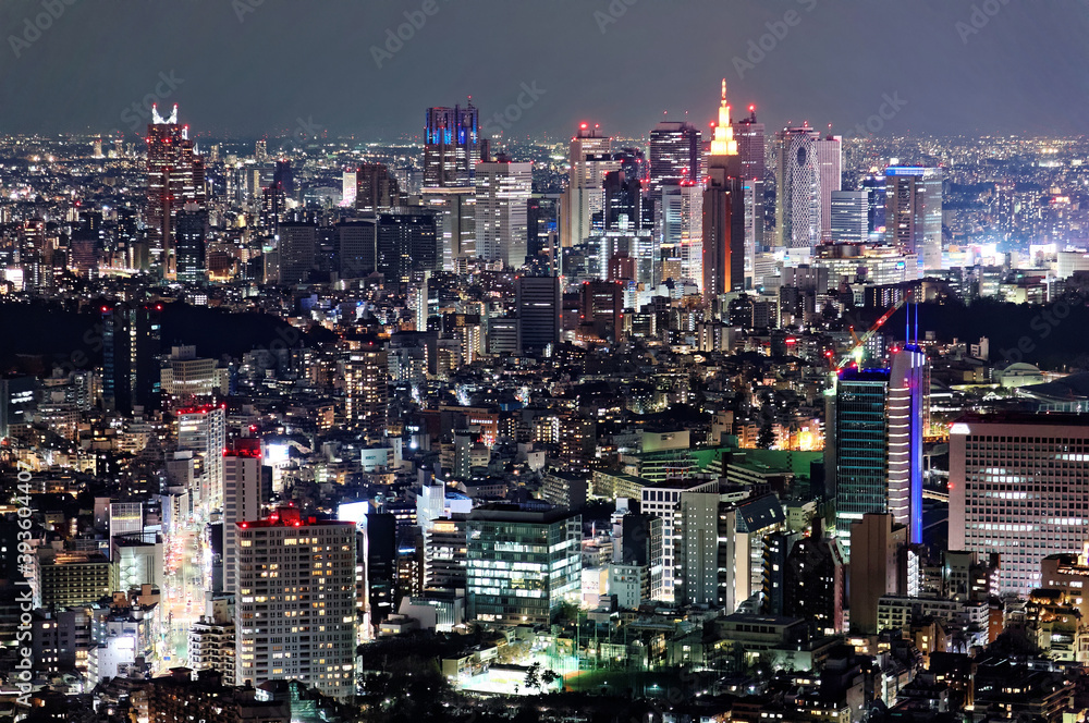 Night skyline of downtown Tokyo with NTT Docomo Yoyogi Building among high rise skyscrapers in ...
