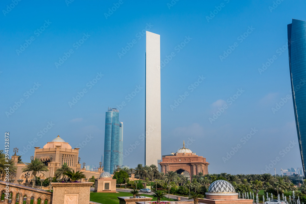 White tall tower against blue sky and the background of main gate of ...