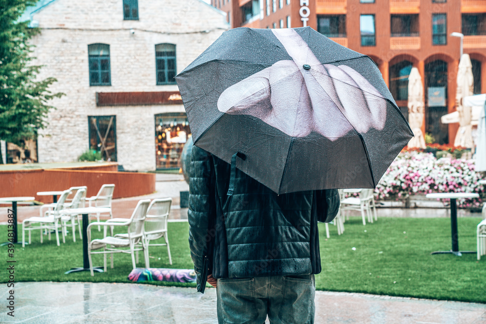 Angry furious man holding umbrella with a middle finger pointing into ...