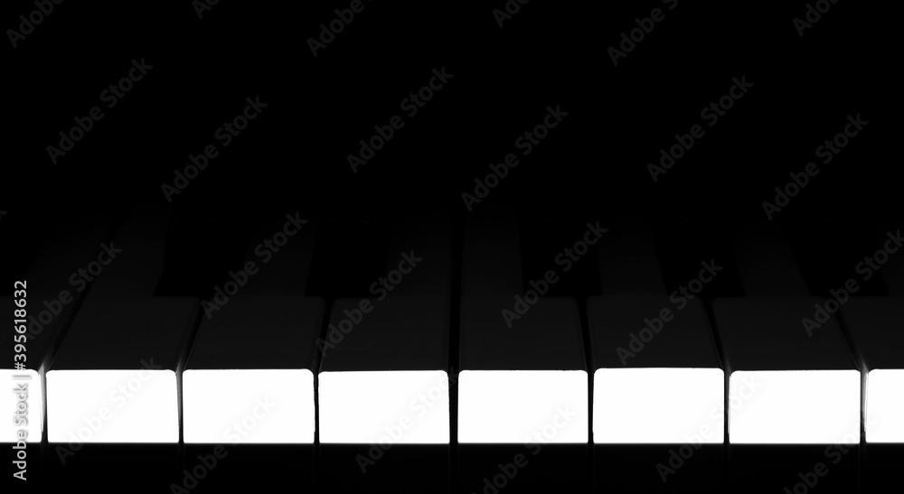 Piano keys in the shade. The side of the piano keyboard is illuminated ...