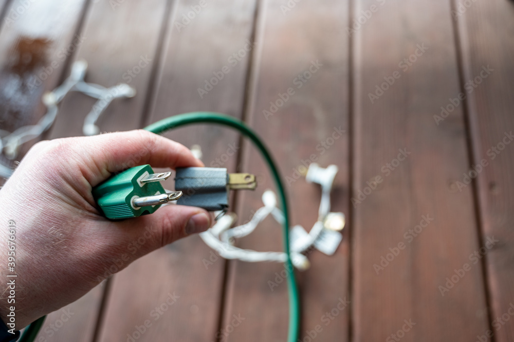 Demonstrating using a 3-prong adapter to connect two power cords Stock ...