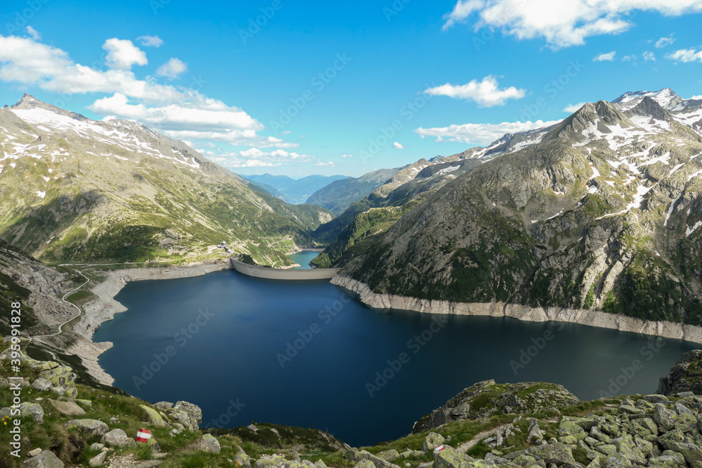 Dam in Austrian Alps. The artificial lake stretches over a vast ...