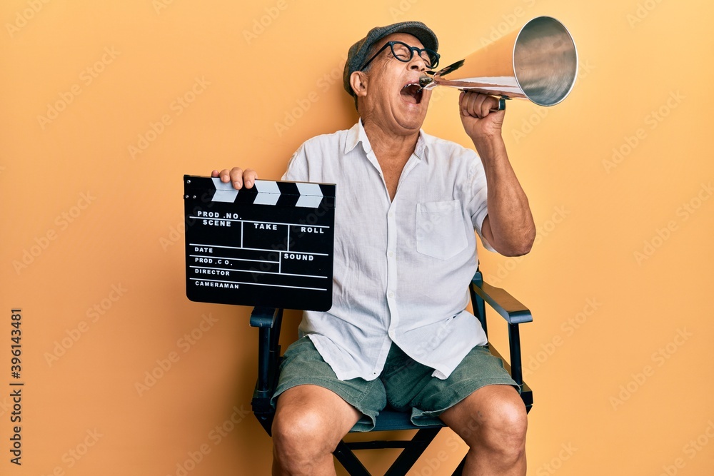 Handsome mature director man holding video film clapboard and louder ...