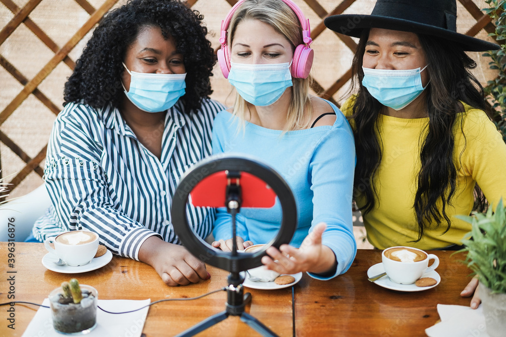 Multiracial girls streaming online using influencer led and phone cam ...