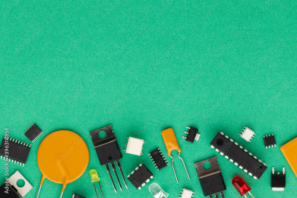 Electronic components over green background with copy space. There are ...