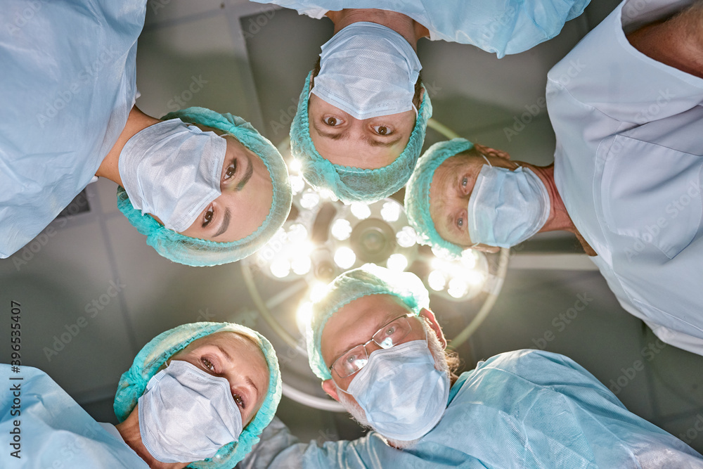 view from below of professional experienced surgeons with medical tools ...