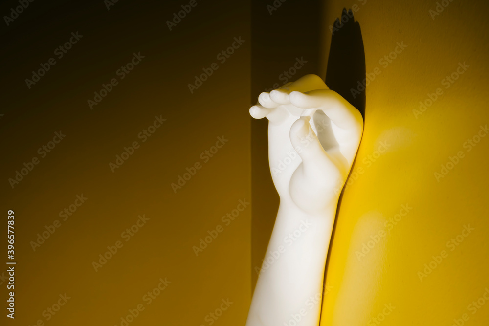 arm of a white dummy model at yellow background. Yellow minimal ...