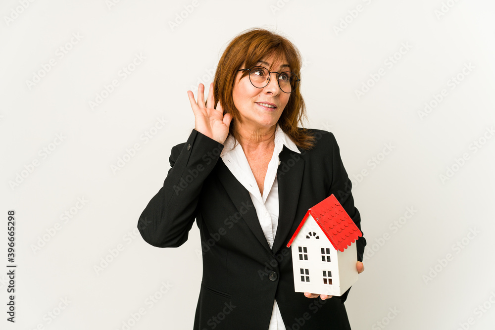 Middle aged real estate agent holding a house model isolated trying to ...