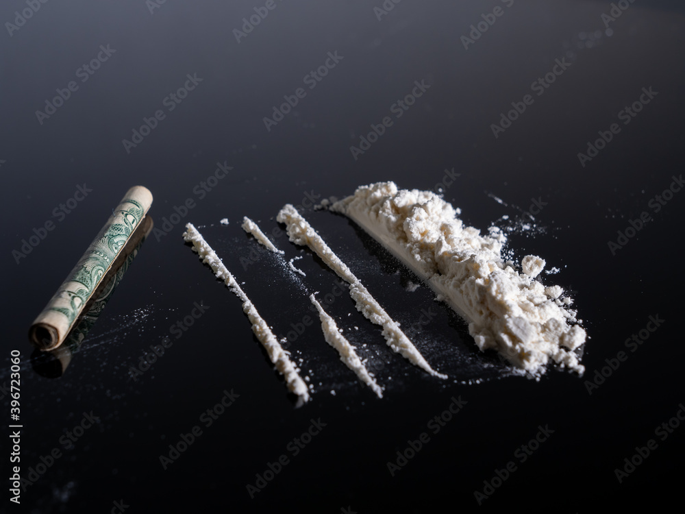 Foto Lines of cocaine and a dollar bill. Cocaine lines shots on a black ...