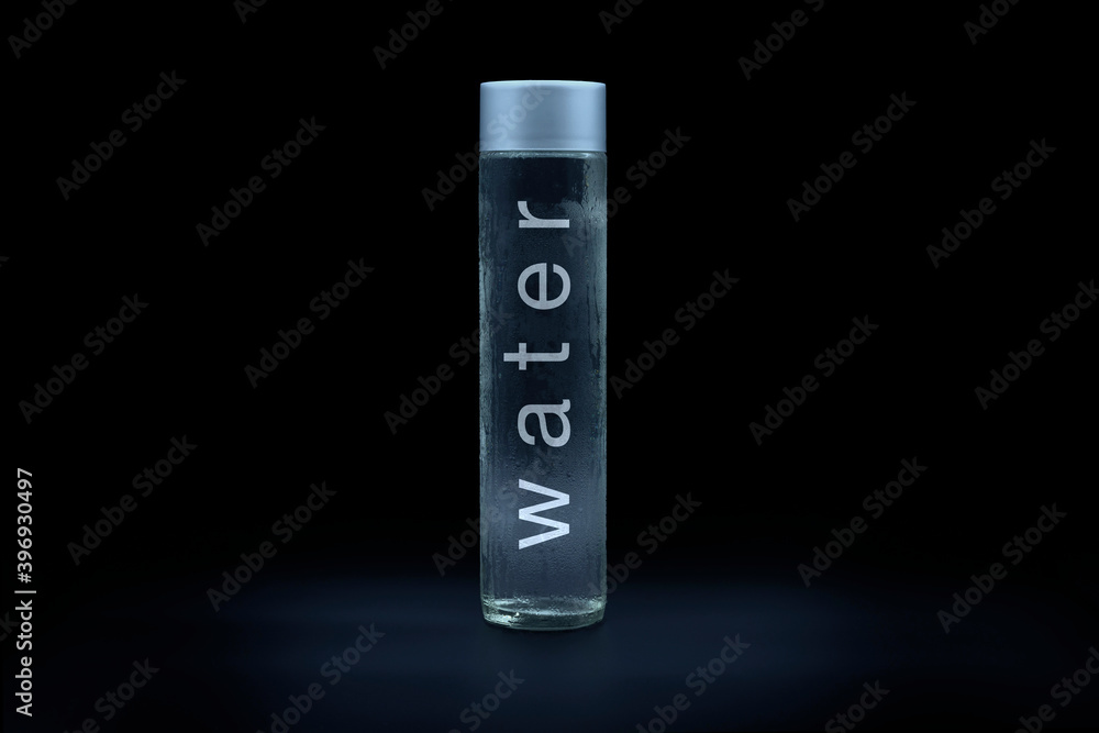 Glass bottle wet with cold water. External surface with drops of ...