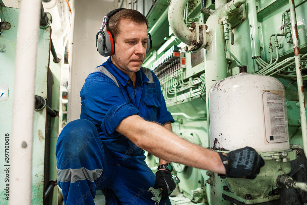 Marine engineer officer controlling vessel engines and propulsion in ...
