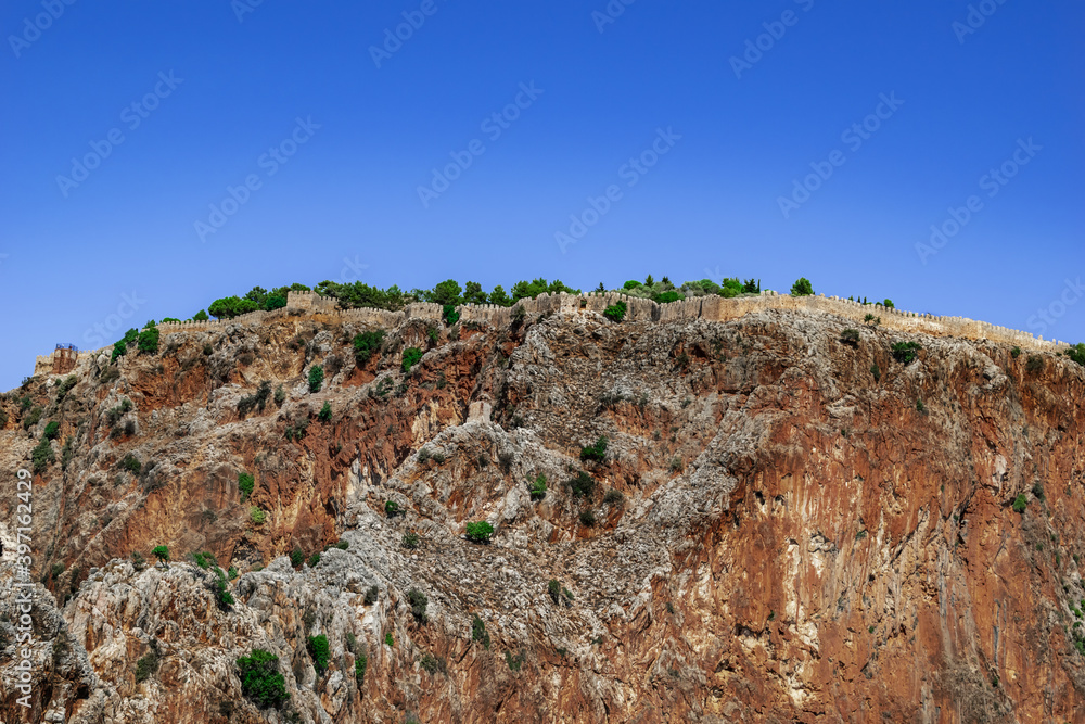 Ancient surrounding wall of Alanya fortress (Turkey) over a steep cliff ...