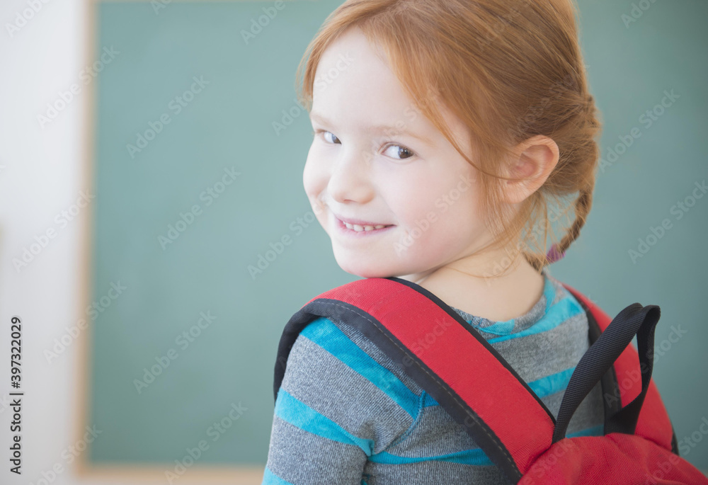 Caucasian girl wearing backpack in classroom Stock Photo | Adobe Stock