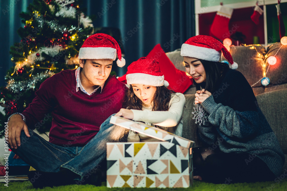 Portrait of happy family father and mother with daughter in santa hats ...
