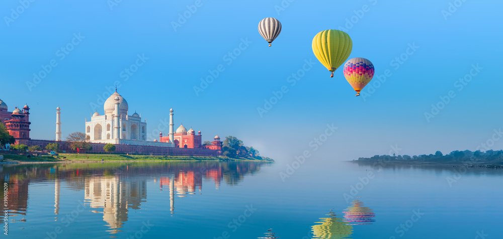 Hot air balloon flying over Taj-Mahal - Taj Mahal mausoleum reflected ...