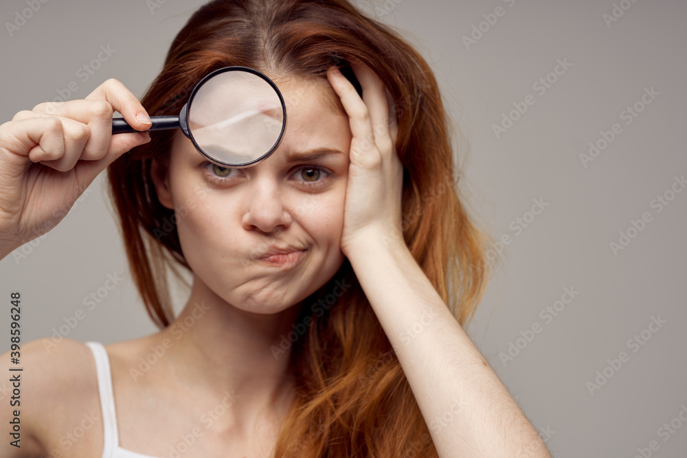 woman with magnifying glass near face acne window health problems ...