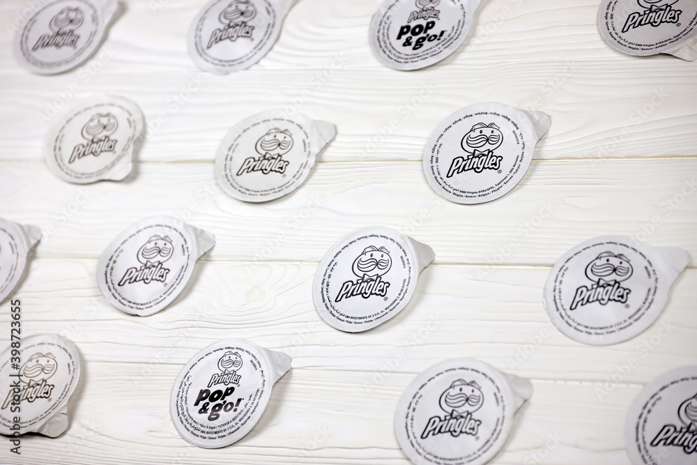 Pringles logo on paper membranes on white wooden table. Pringles is a ...