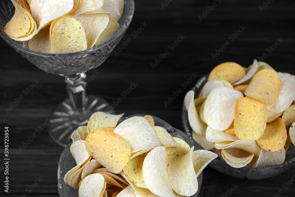 Foto de Stock Many orange Pringles potato snack chips on black wooden ...