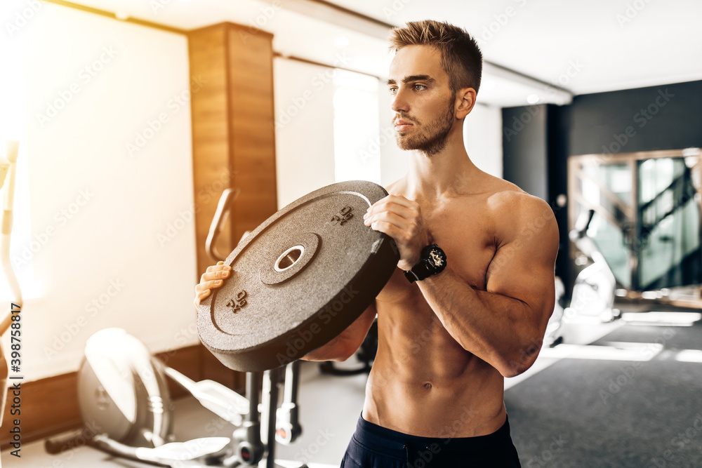 muscular sports guy, shirtless, bodybuilder performs exercises with ...