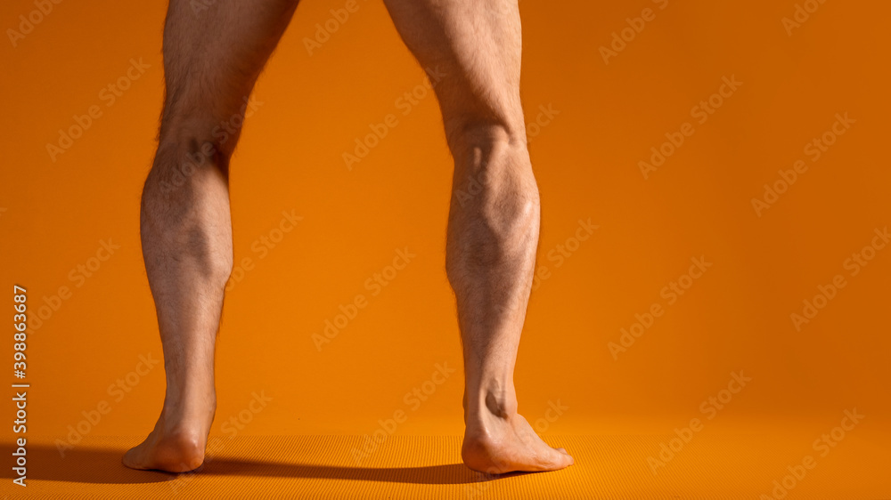 Muscular men's legs in squat, swing leg muscles, exercise. Parts of the ...