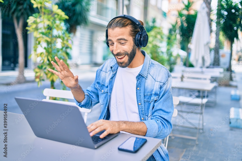 Young middle eastern man doing video call using laptop and headphones ...