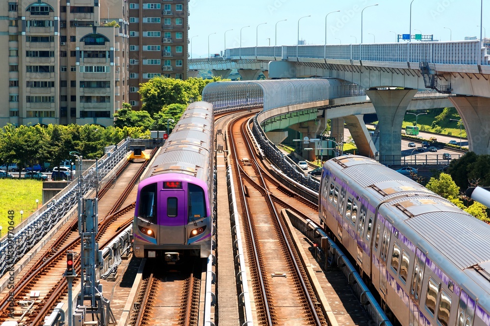 Cityscape with view of metro trains traveling on elevated rails of ...