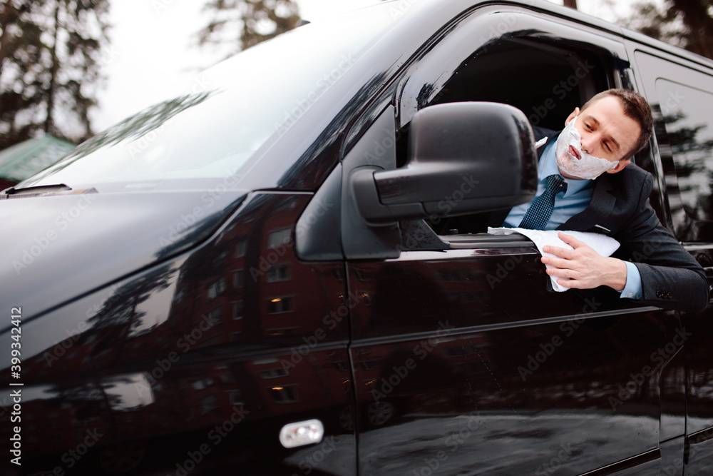 Photo Stock Businessman shaving in car by razor and foam at the wheel ...