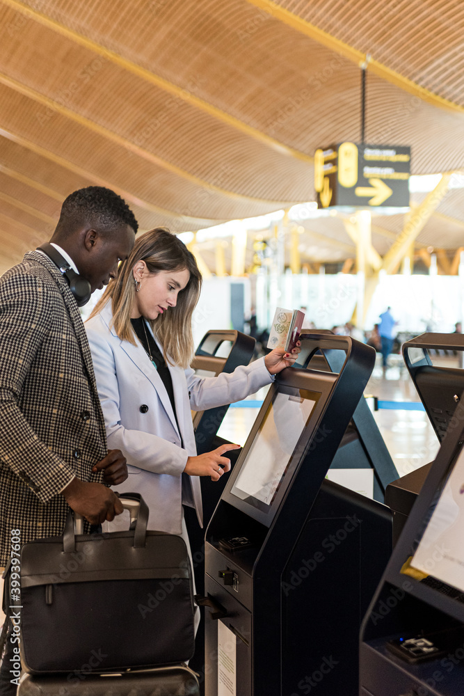 coworkers using the check-in machine at the airport getting the ...