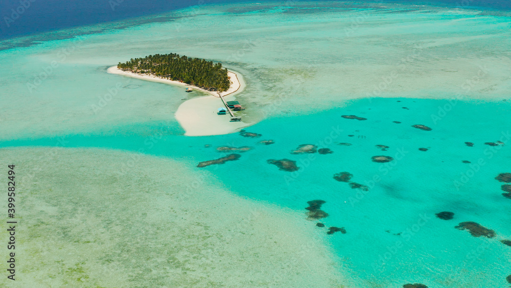 Tropical island among coral reefs with a white beach and blue atoll ...
