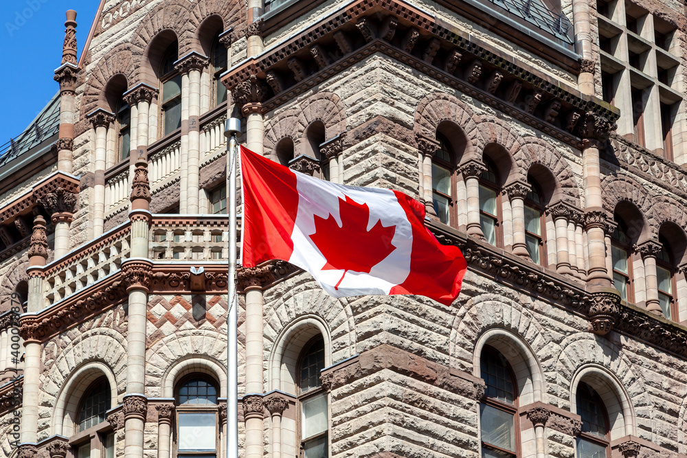 The waving Canadian flag with Old City Hall in background in Toronto ...