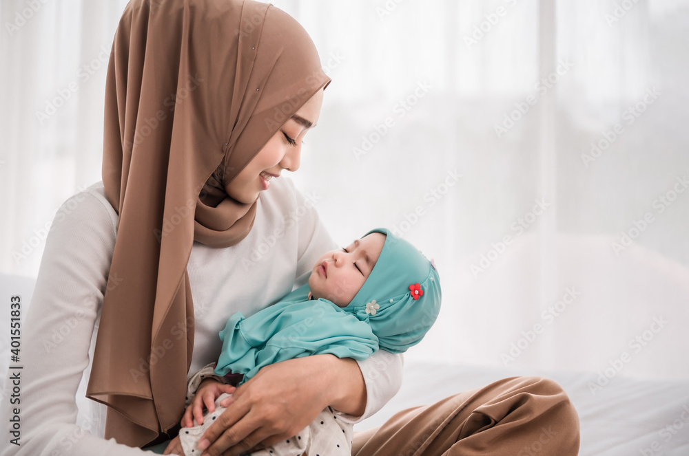 Happy muslim mother holding adorable little baby daughter wearing hijab ...