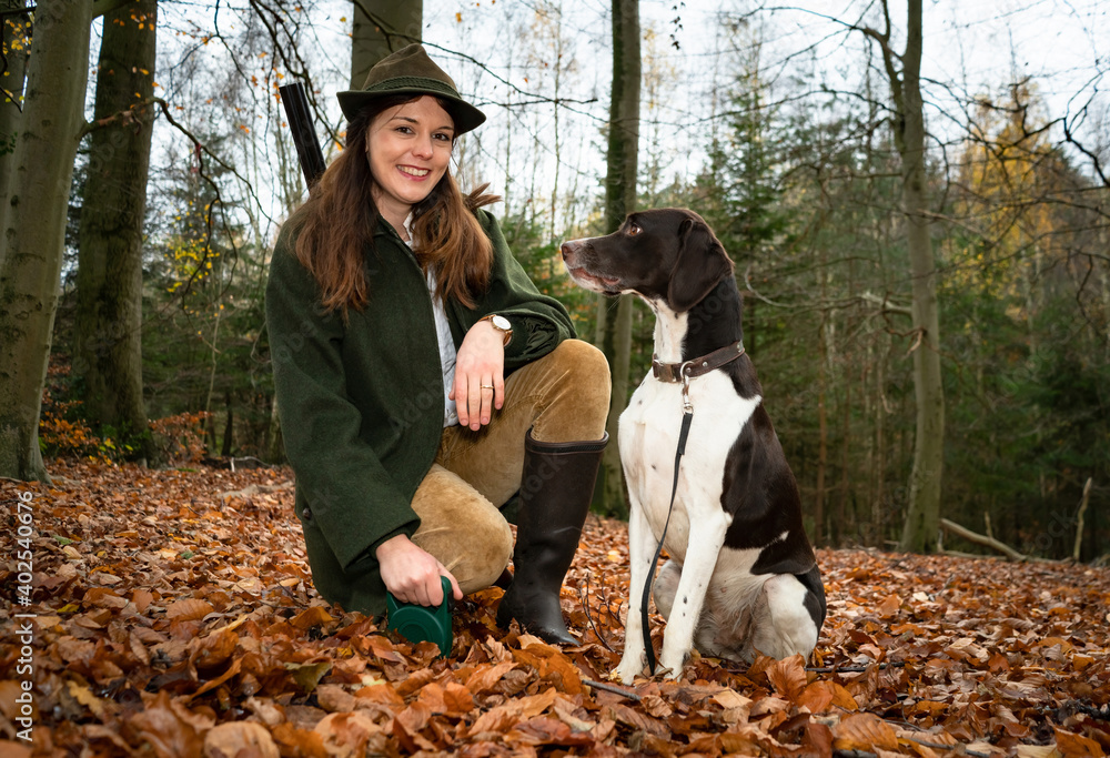 Jagd und Wildhege, junge Jägerin mit ihrem Jagdhund bei einem ...