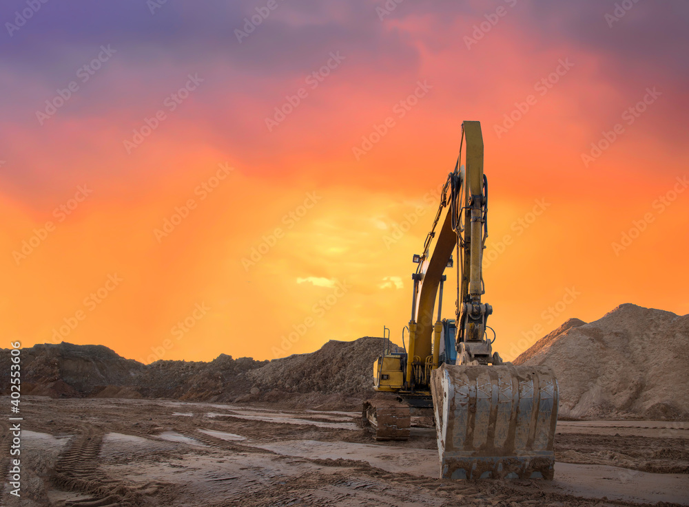 Excavator working on earthmoving at open pit mining on amazing sunset ...