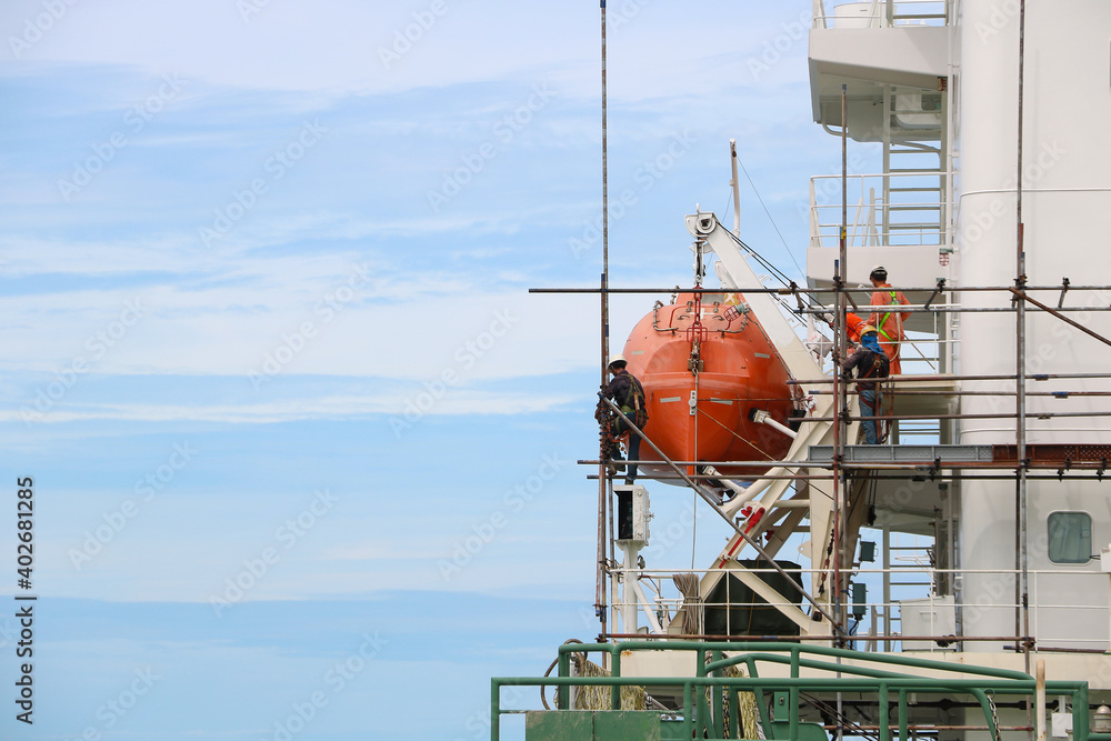 safety Lifeboat or rescue boat in shipyard with worker wearing safety ...